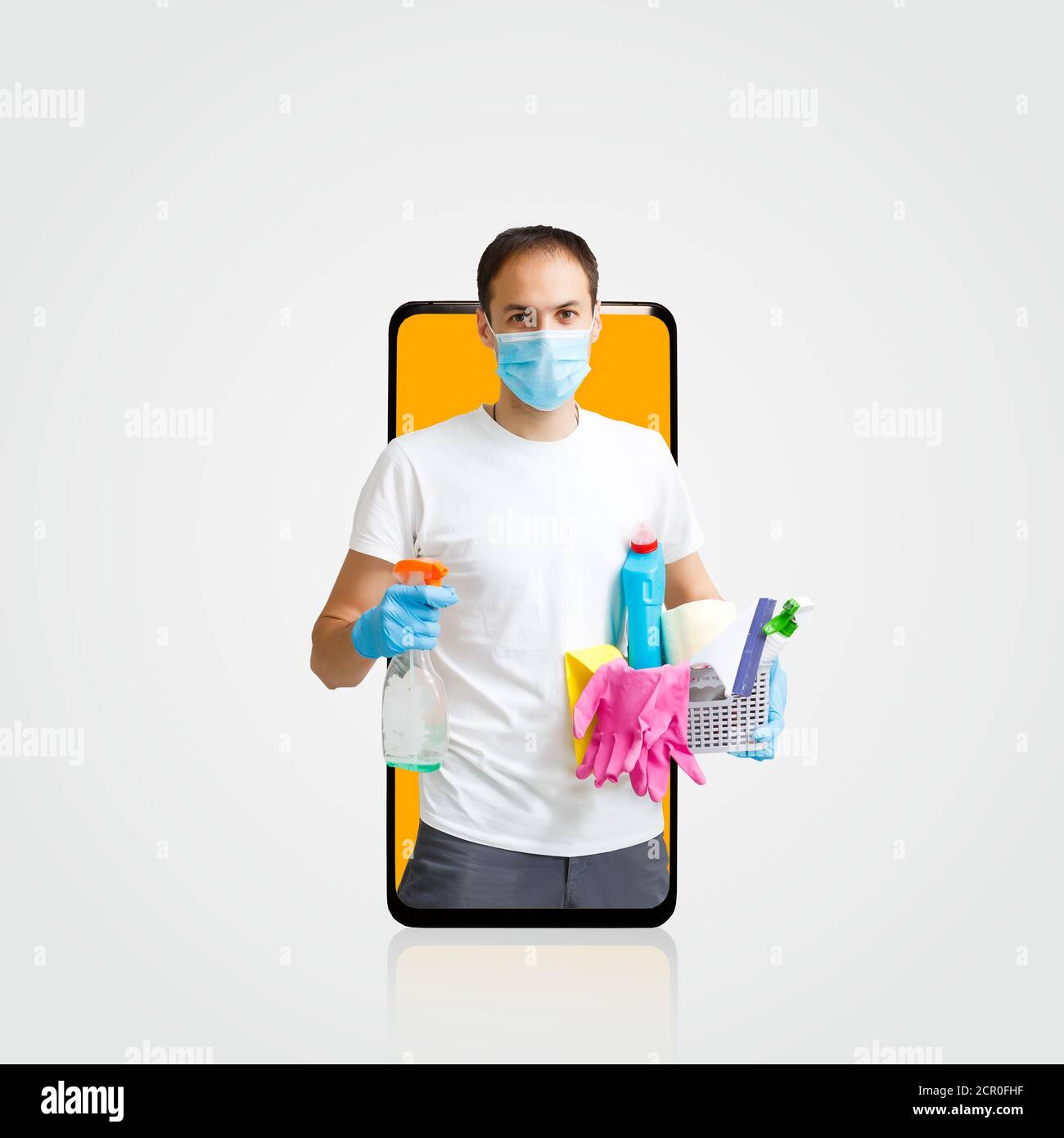 Cleaning man with a bucket and cleaning products on color background ...