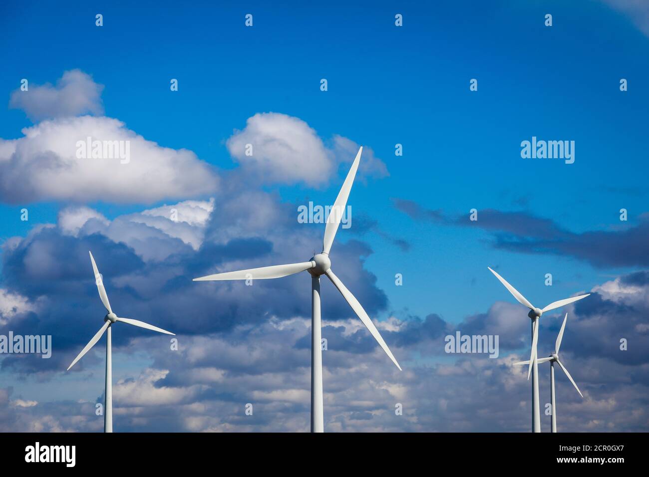 Wind wheels against a blue sky with clouds, Ense, North Rhine ...