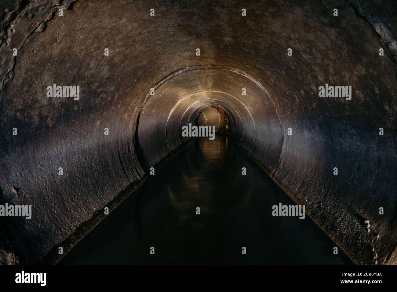 Flooded round sewer tunnel with water reflection Stock Photo - Alamy