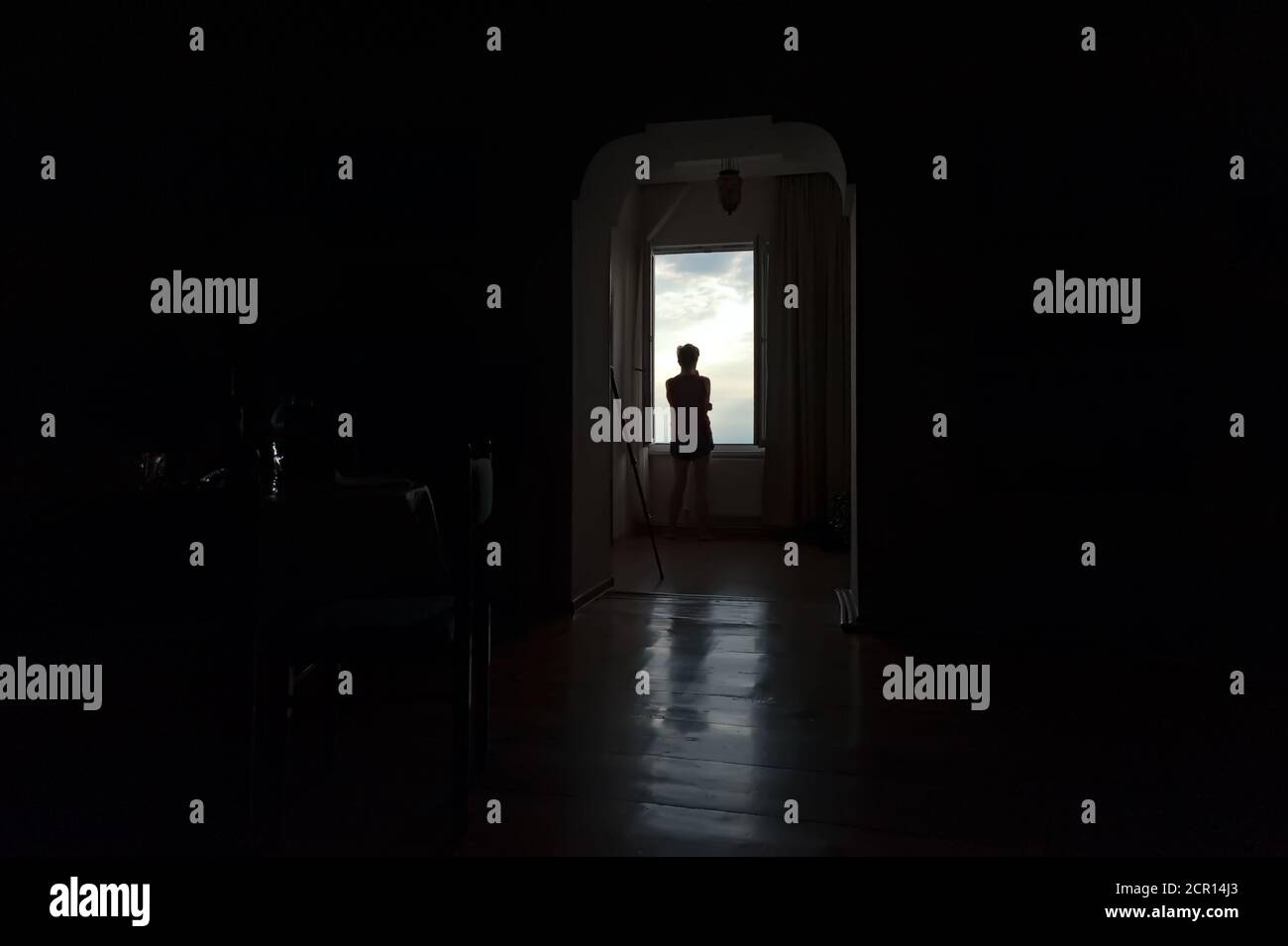 Person silhouette in the window in the dark room Stock Photo - Alamy
