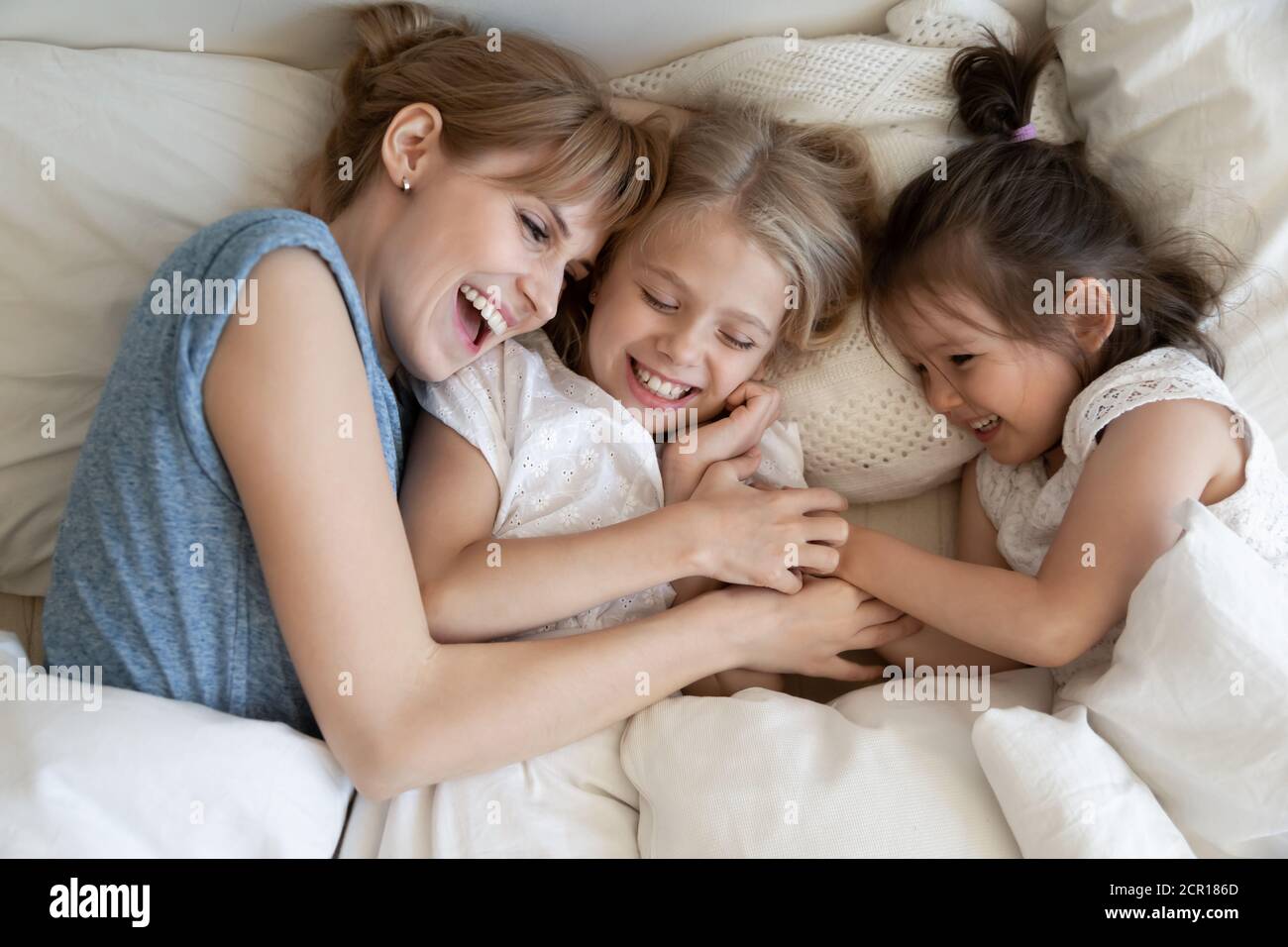 Mum and kids cuddling in bed Stock Photo - Alamy