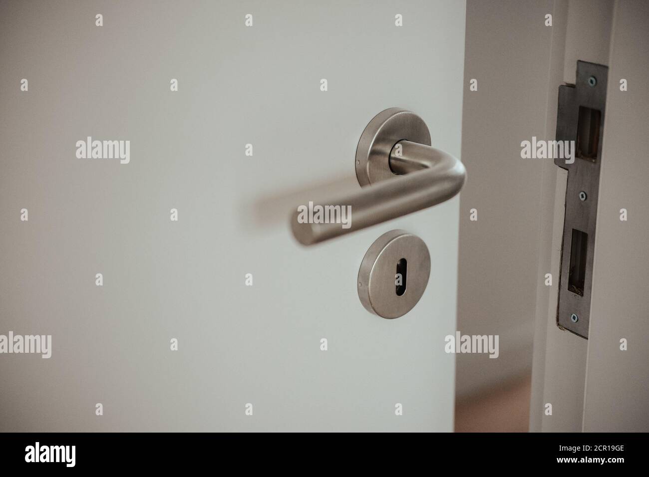 Partly opened door with a handle Stock Photo - Alamy