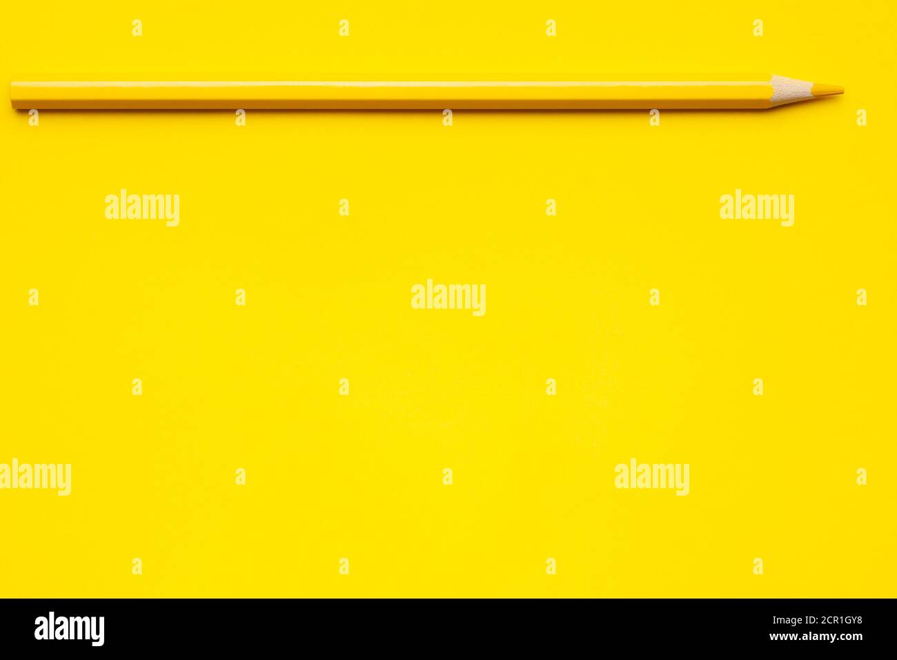 horizontal yellow sharp wooden pencil on a bright yellow background ...
