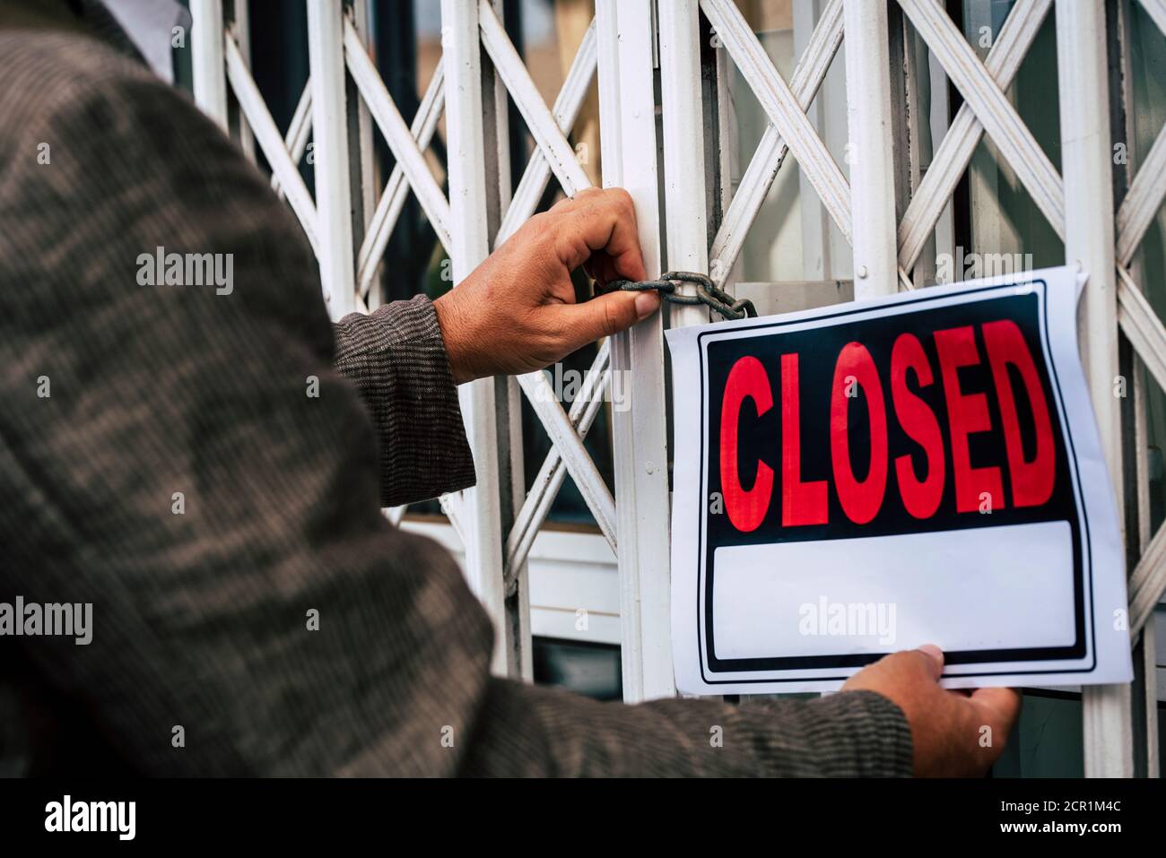 Close up of business people man with closed sign outside the shop and ...