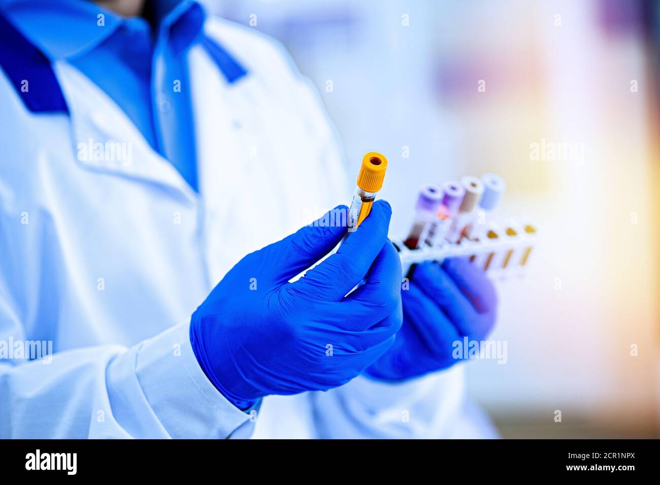 Hands in rubber gloves hold test tubes Stock Photo - Alamy