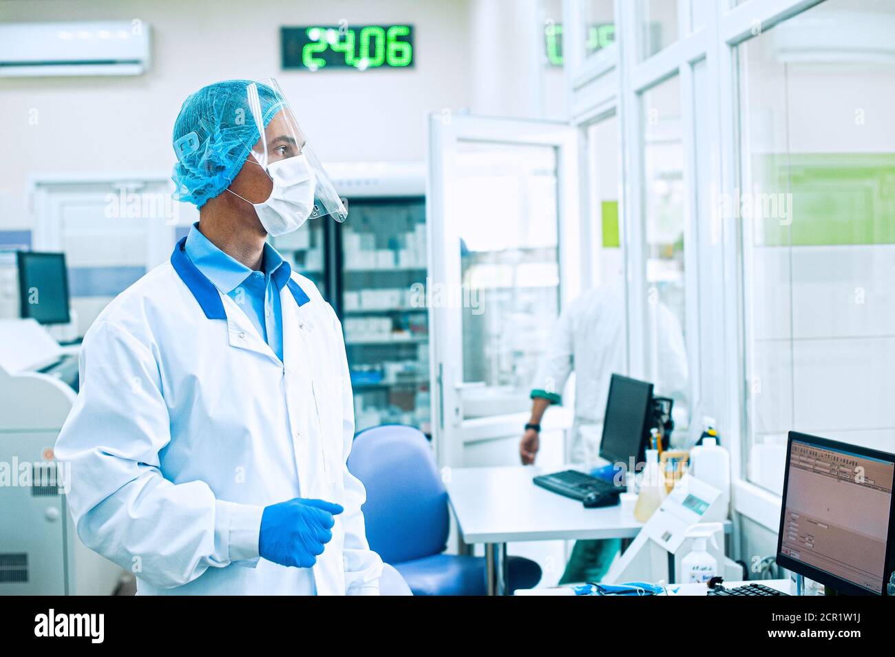A medical worker, a laboratory assistant in a protective mask, visor ...