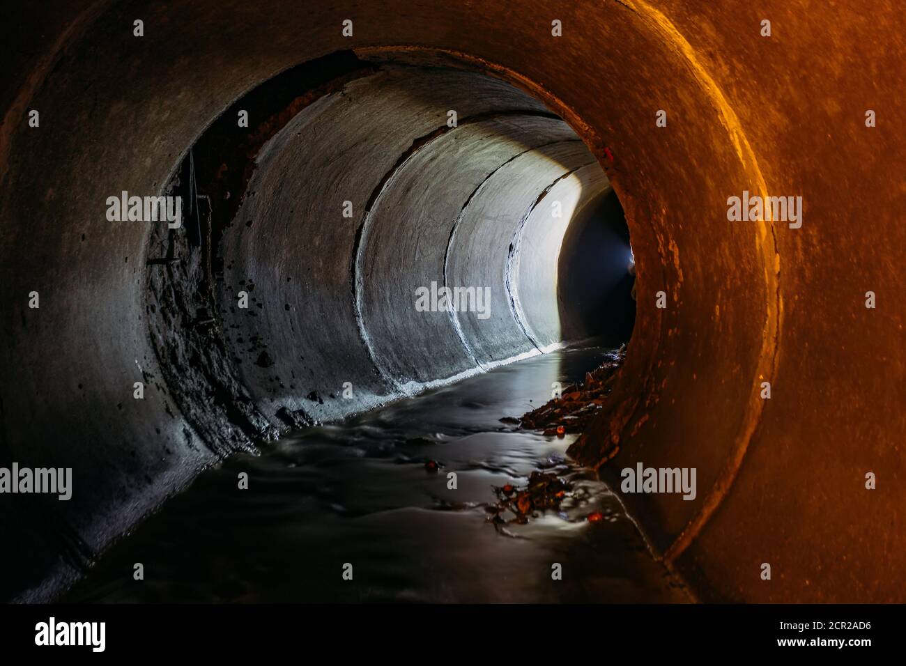 Flooded round sewer tunnel with water reflection Stock Photo - Alamy