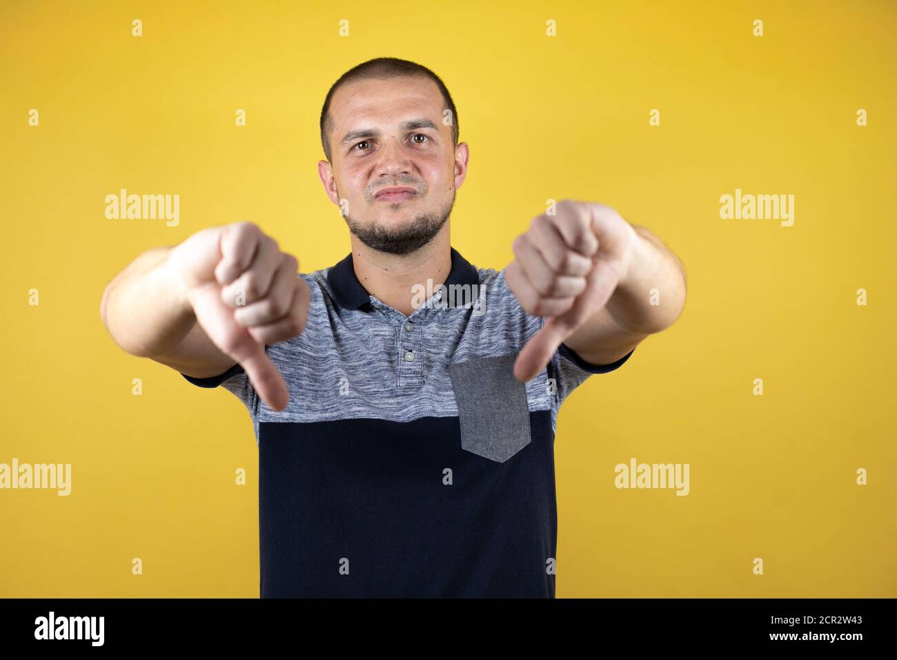 Russian man standing over insolated yellow background looking unhappy ...