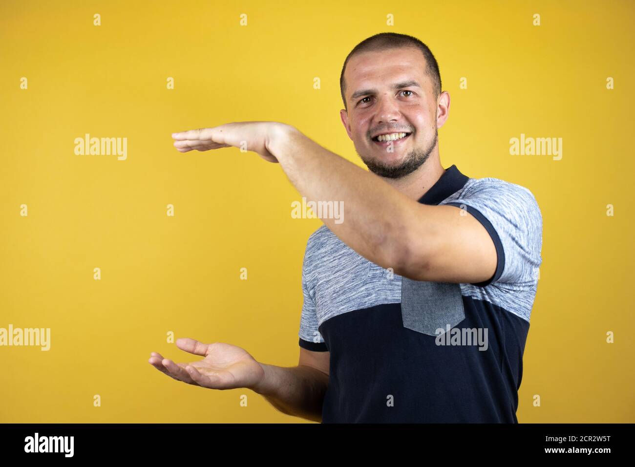 Russian man standing over insolated yellow background surprised and ...