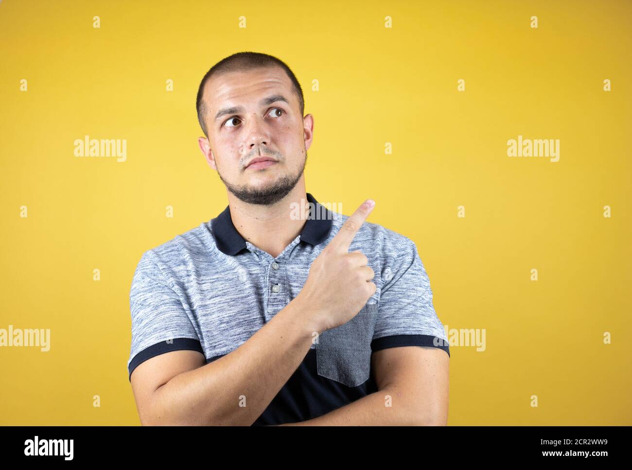 Russian man standing over insolated yellow background pointing finger ...