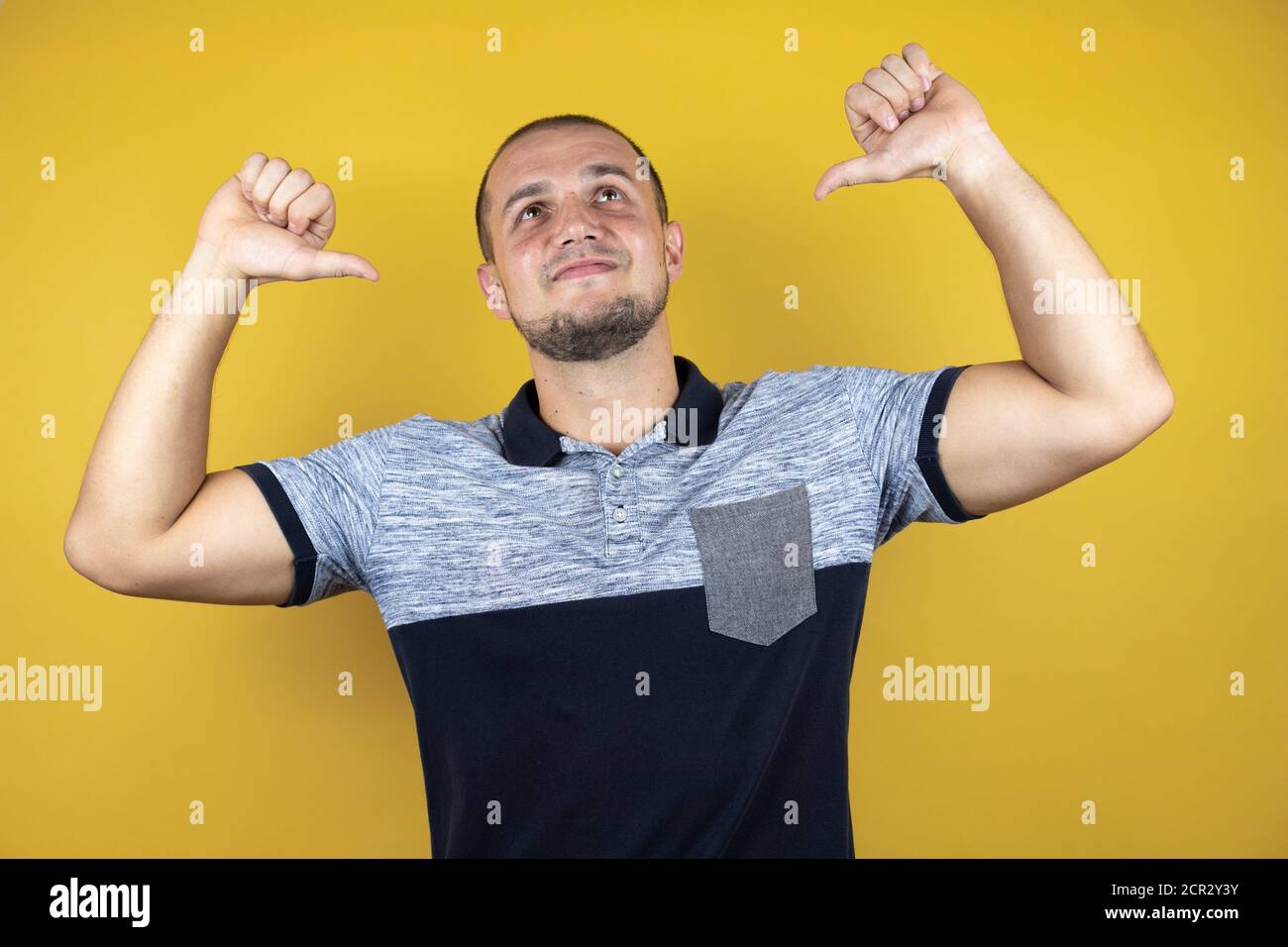 Russian man standing over insolated yellow background looking confident ...