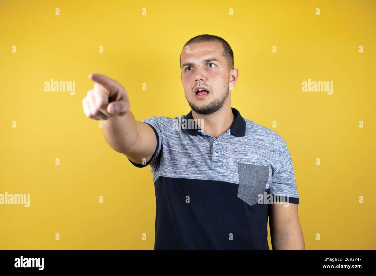 Russian man standing over insolated yellow background pointing with ...