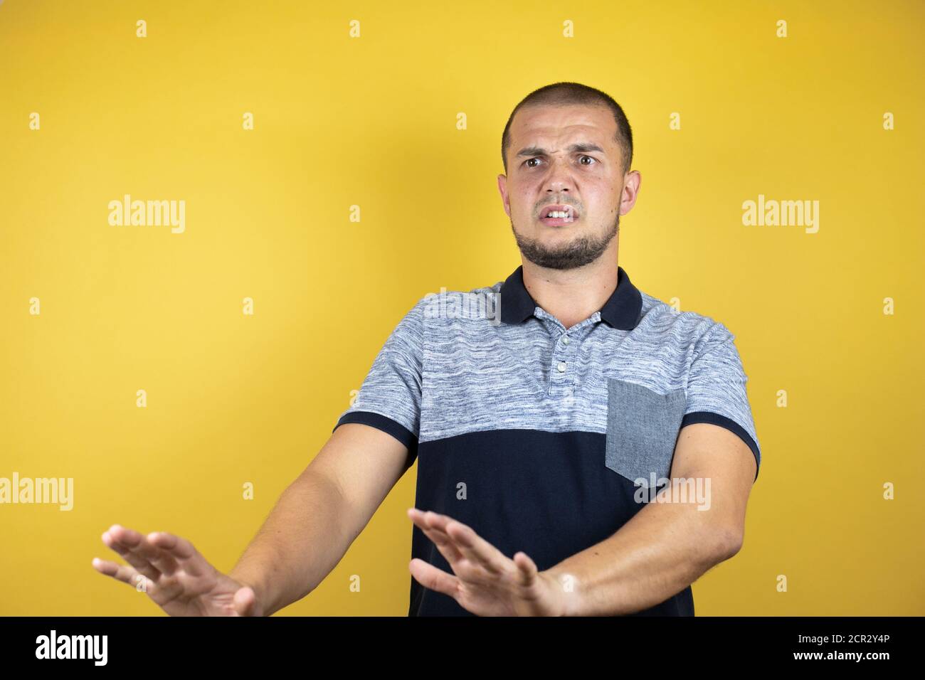 Russian man standing over insolated yellow background afraid and ...