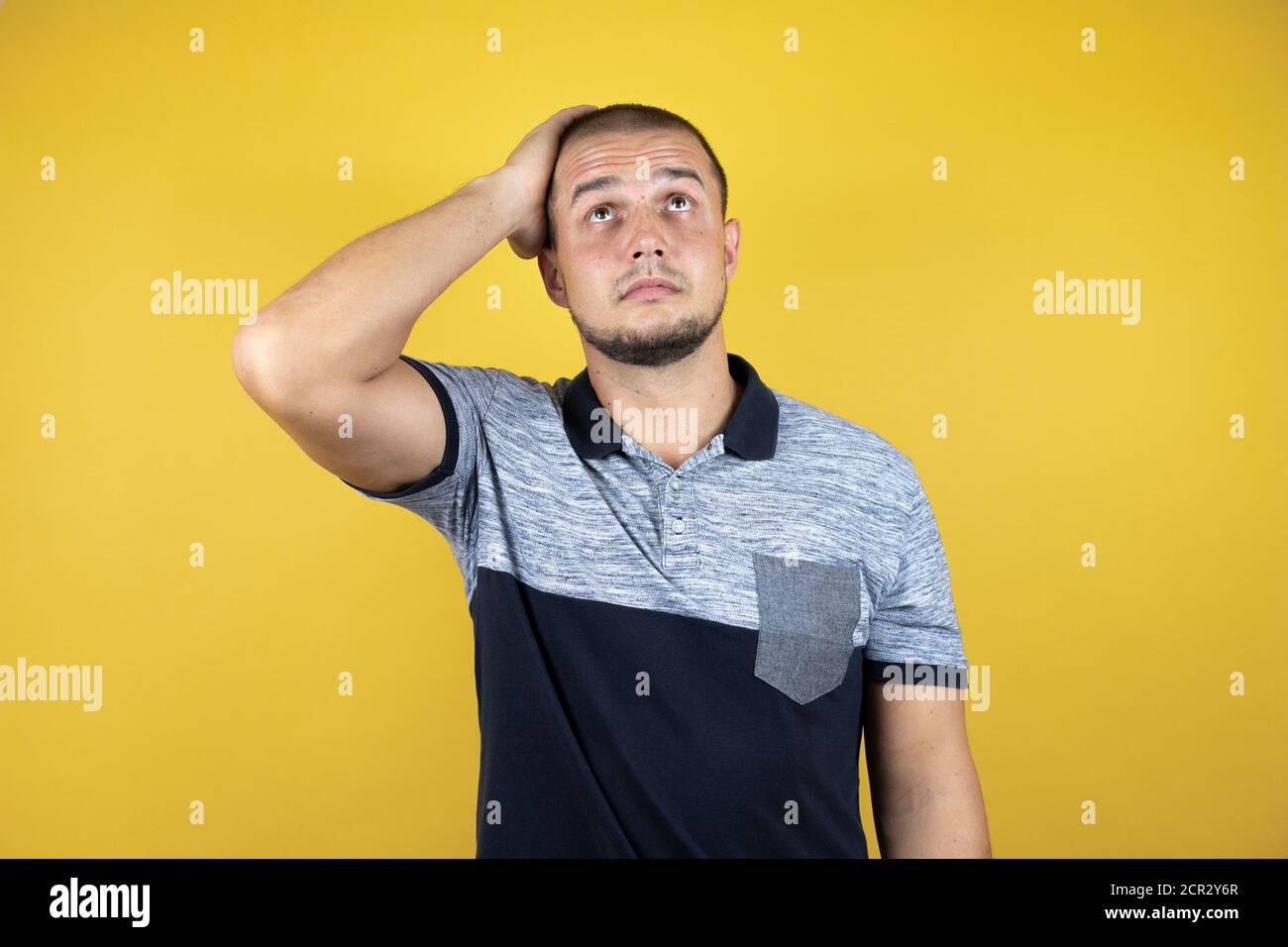 Russian man standing over insolated yellow background worried and ...