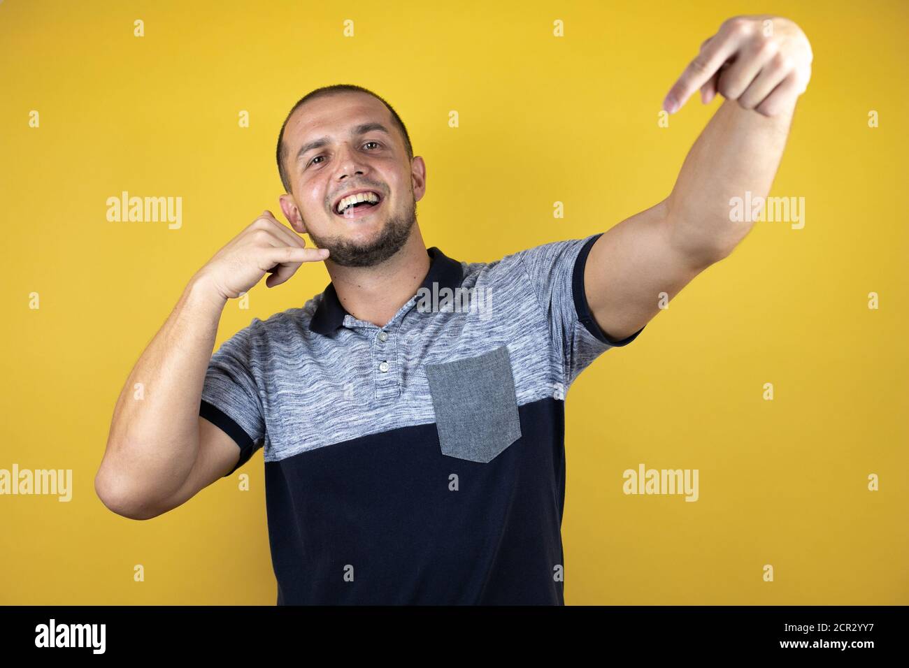 Russian man standing over insolated yellow background smiling doing ...