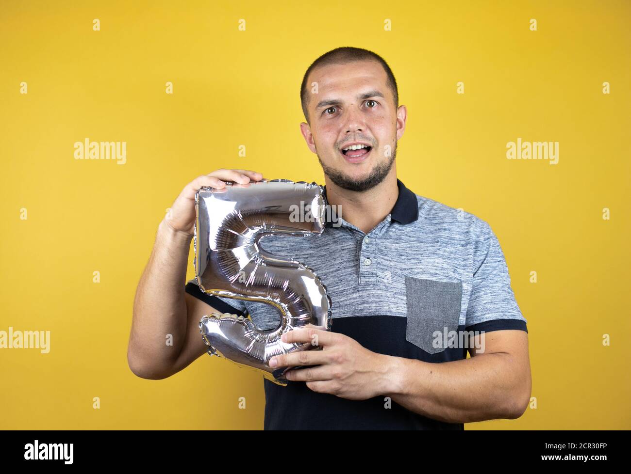 Russian man standing over insolated yellow background smiling holding a ...