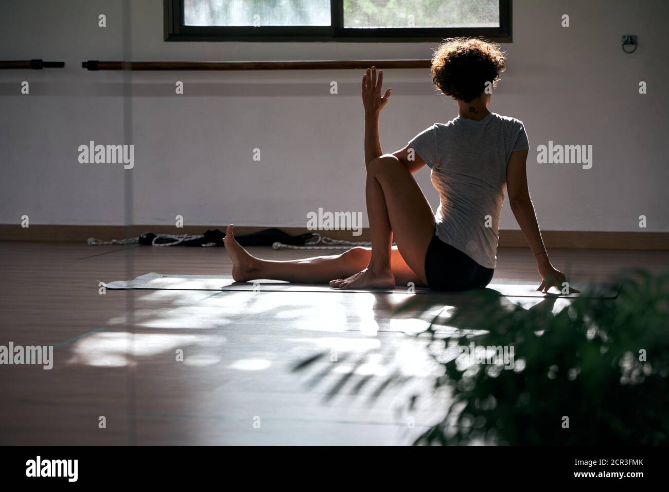 Spinal twist yoga pose in the studio, woman doing yoga asana ardha ...