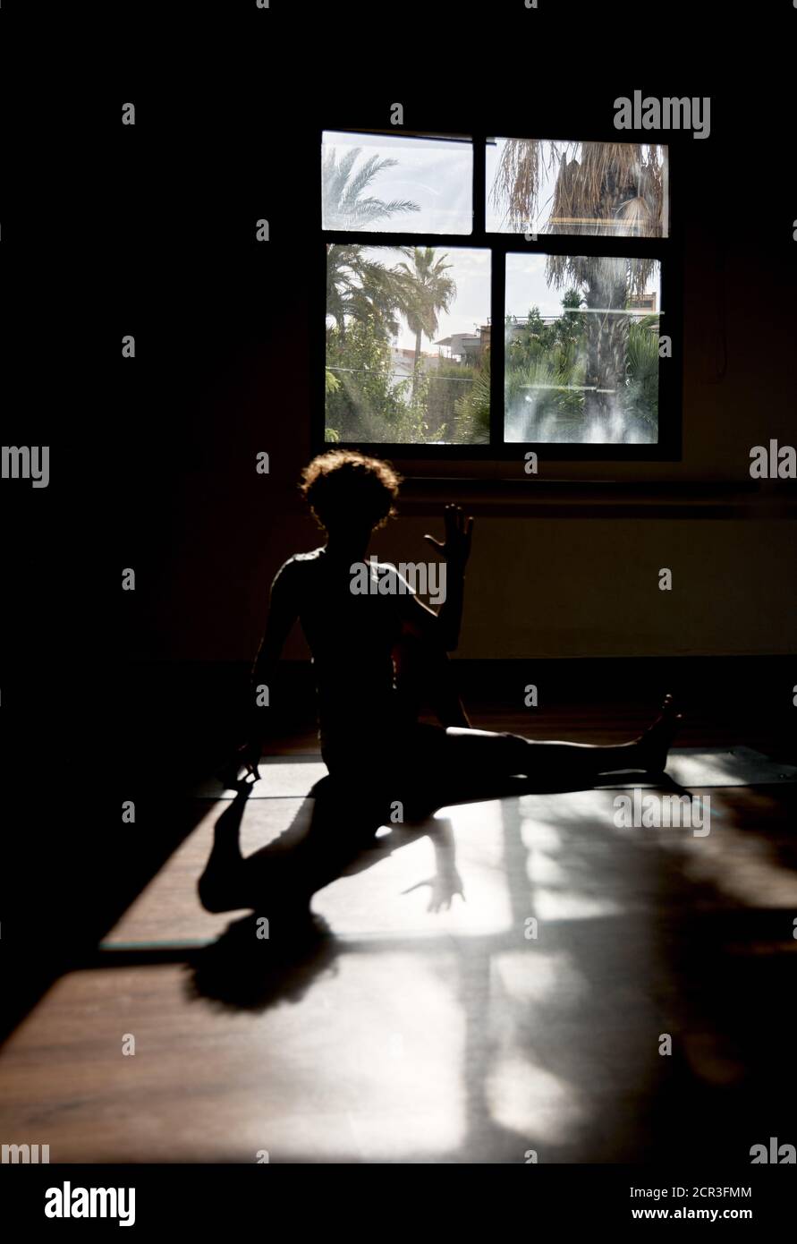 Spinal twist yoga pose in the studio, woman doing yoga asana ardha ...