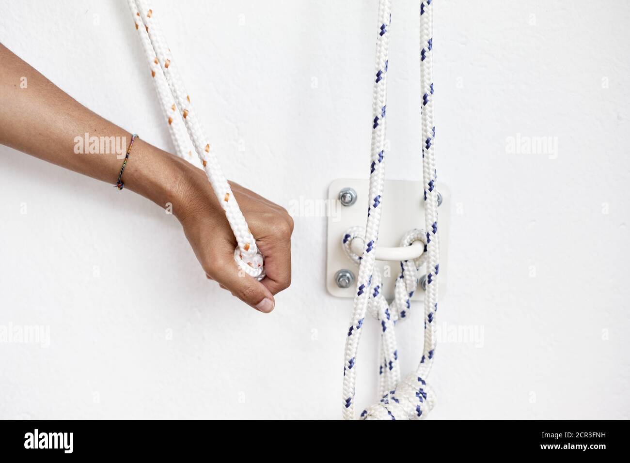 Closeup hands holding the rope, iyengar yoga at studio, stretching with ...