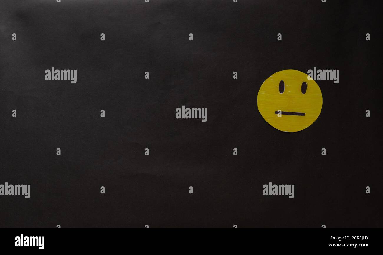 Overhead shot of a paper cutout of an neutral face representing ...