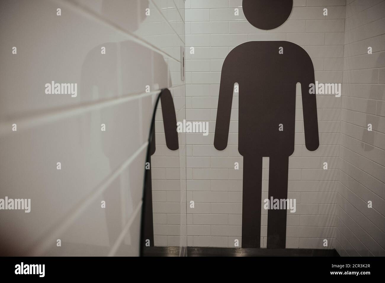 Male figure on a wall representing a toilet for men Stock Photo - Alamy
