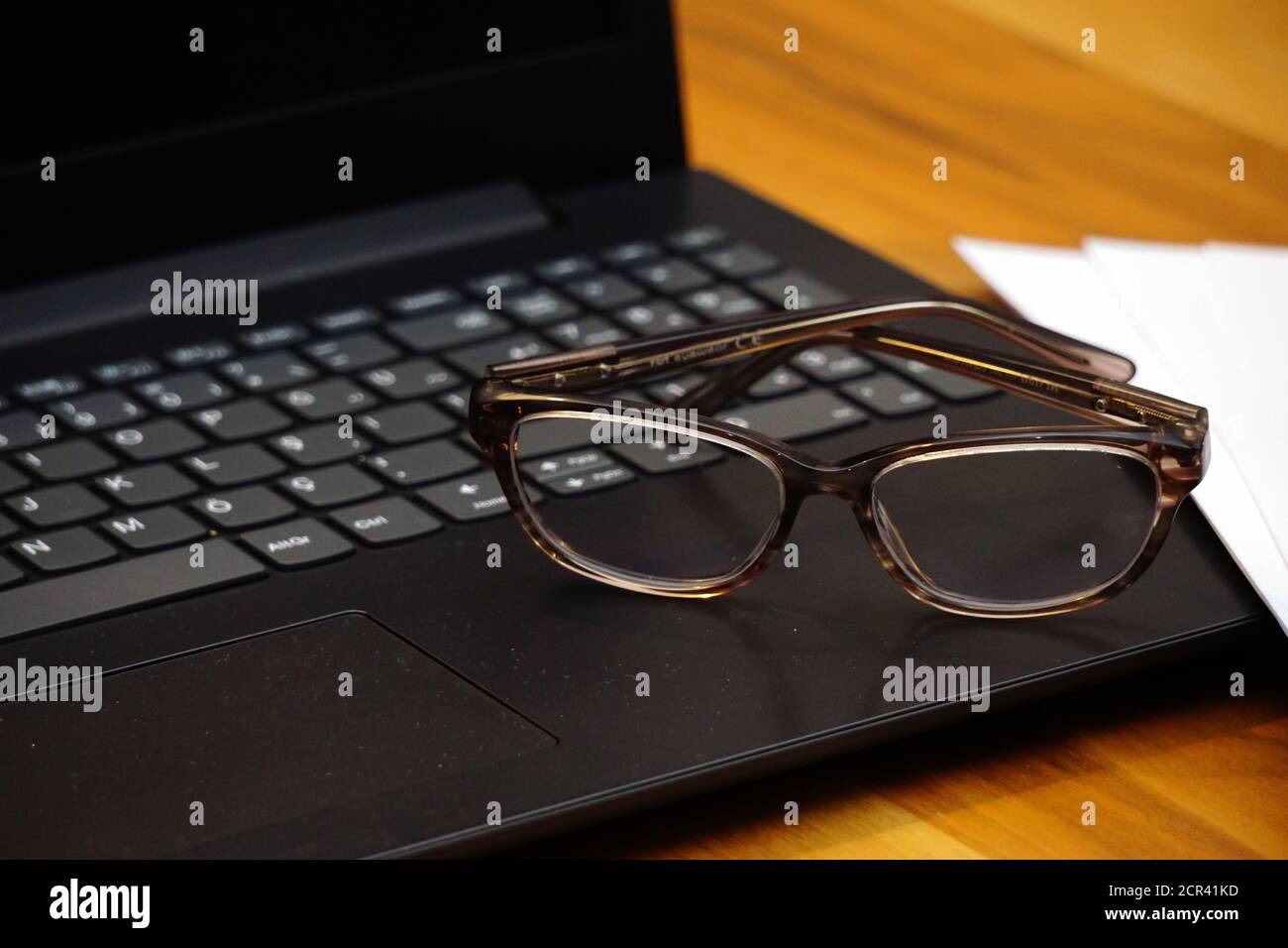 Glasses laptop keyboard and notes on wooden background business concept ...