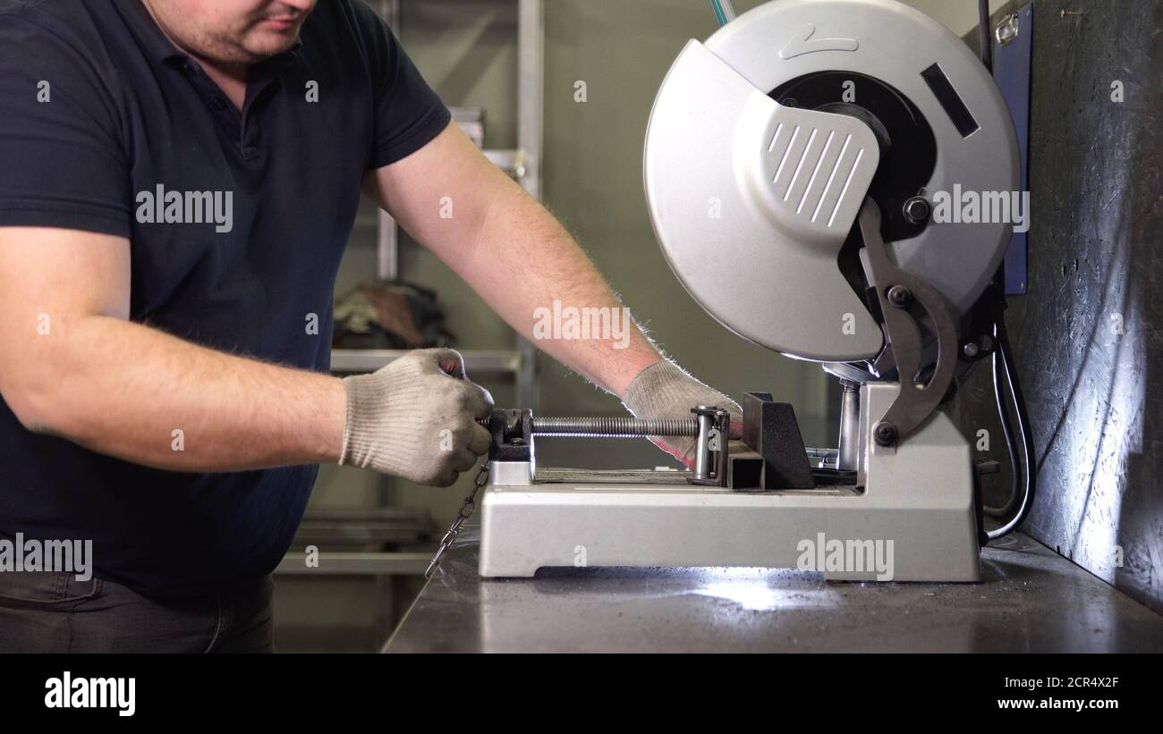 Hand in gloves at grinding machine. Sawing metal. Male hard work ...