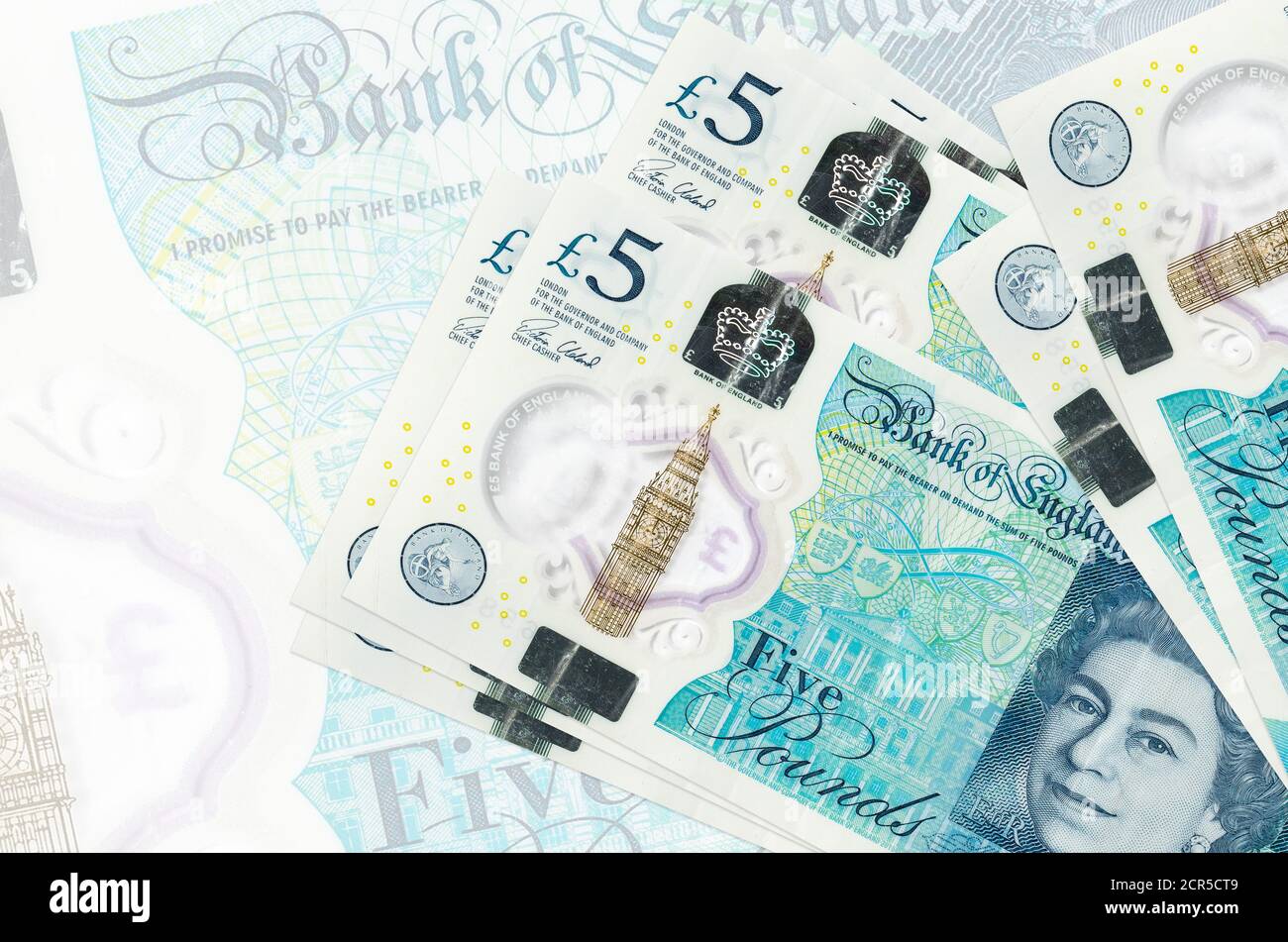 5 British pounds bills lies in stack on background of big semi ...