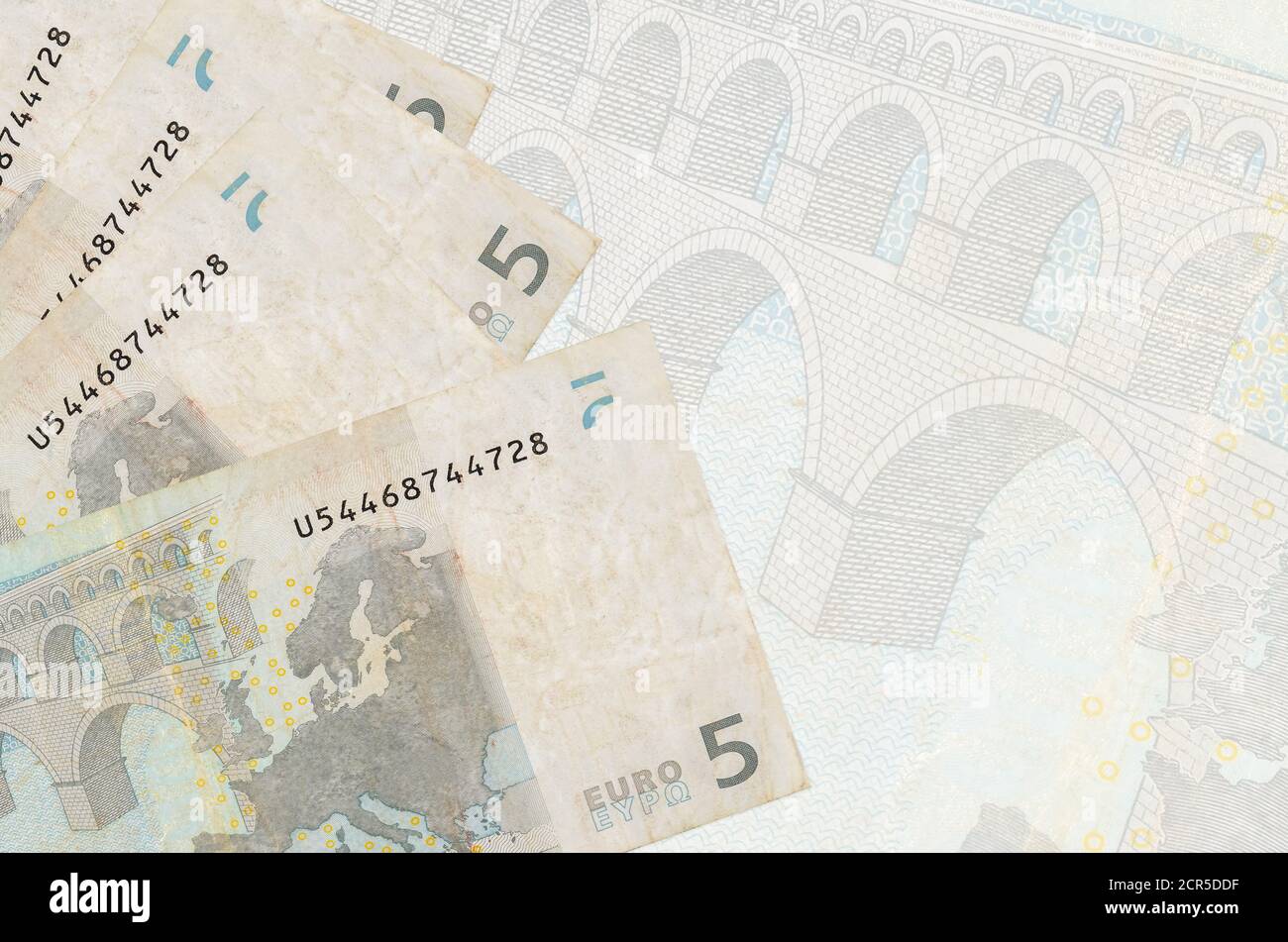 5 euro bills lies in stack on background of big semi-transparent ...