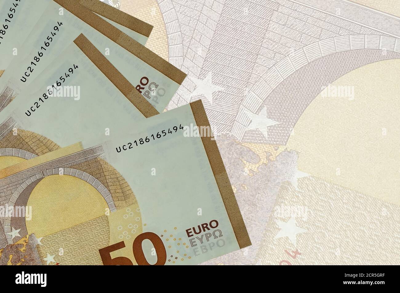 50 euro bills lies in stack on background of big semi-transparent ...