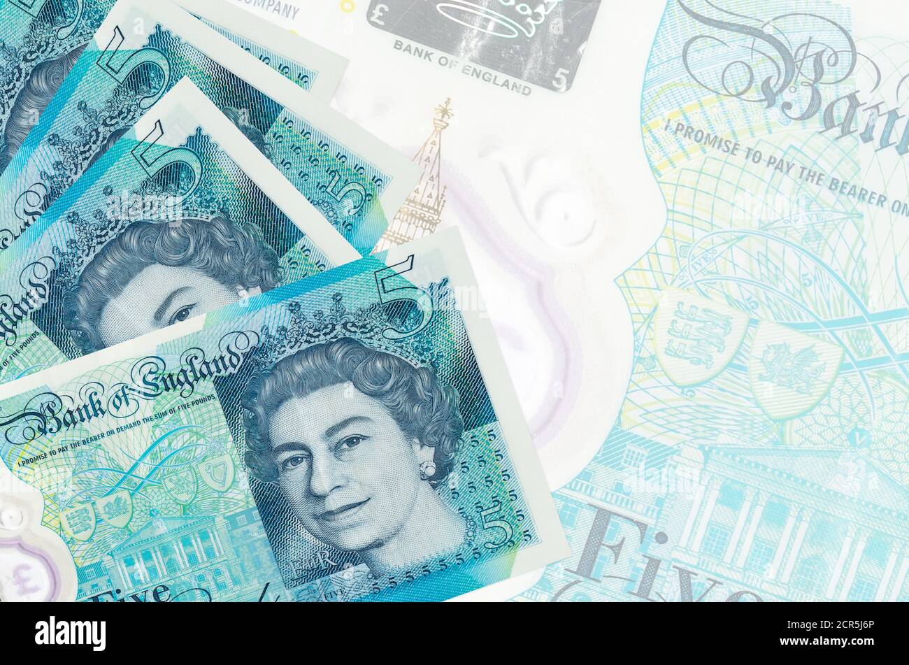 5 British pounds bills lies in stack on background of big semi ...