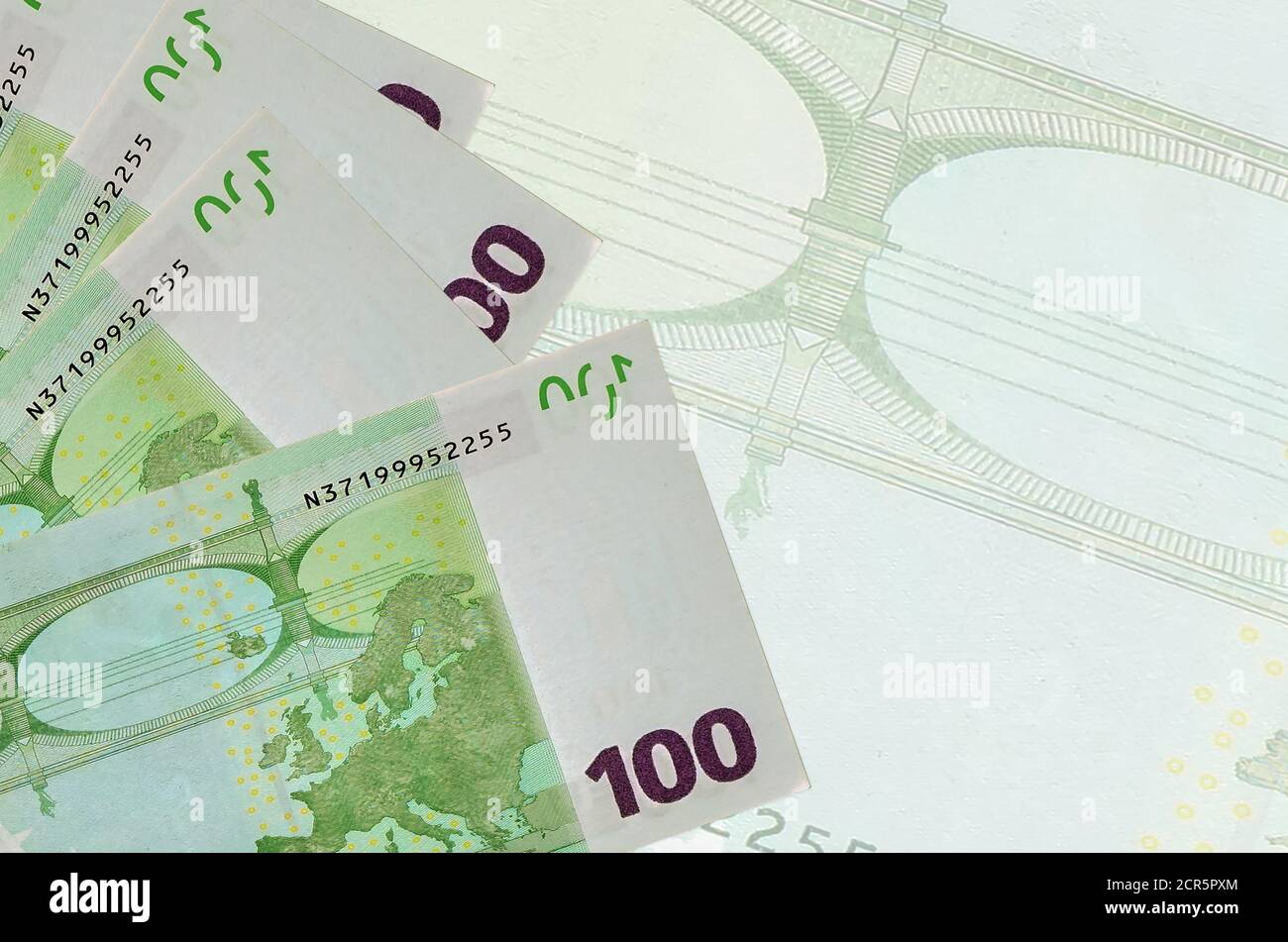 100 Euro bills lies in stack on background of big semi-transparent ...