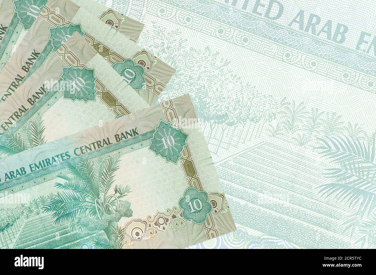 10 UAE dirhams bills lies in stack on background of big semi ...