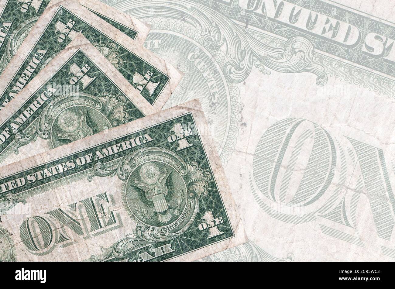 1 US dollar bills lies in stack on background of big semi-transparent ...