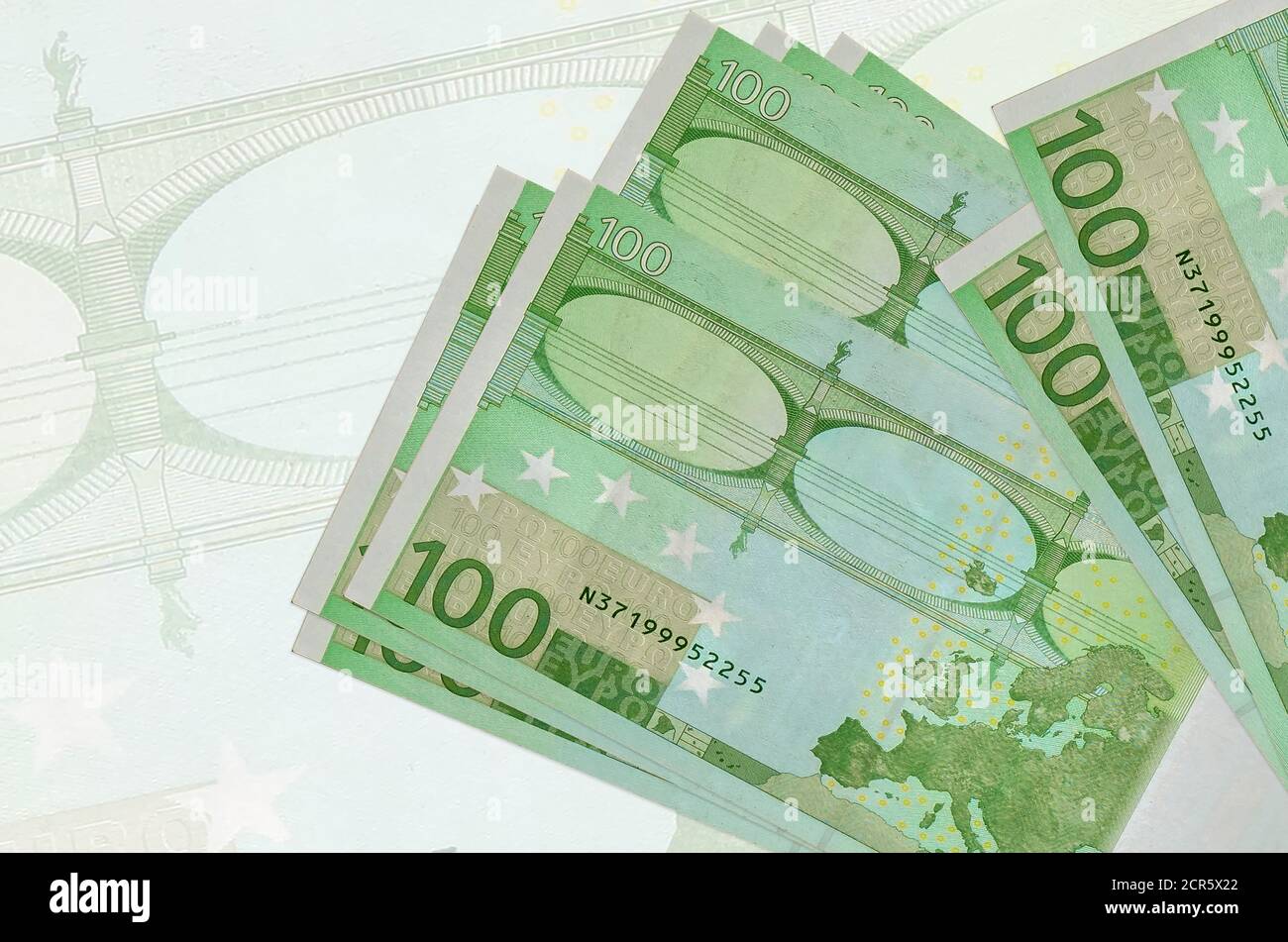 100 Euro bills lies in stack on background of big semi-transparent ...