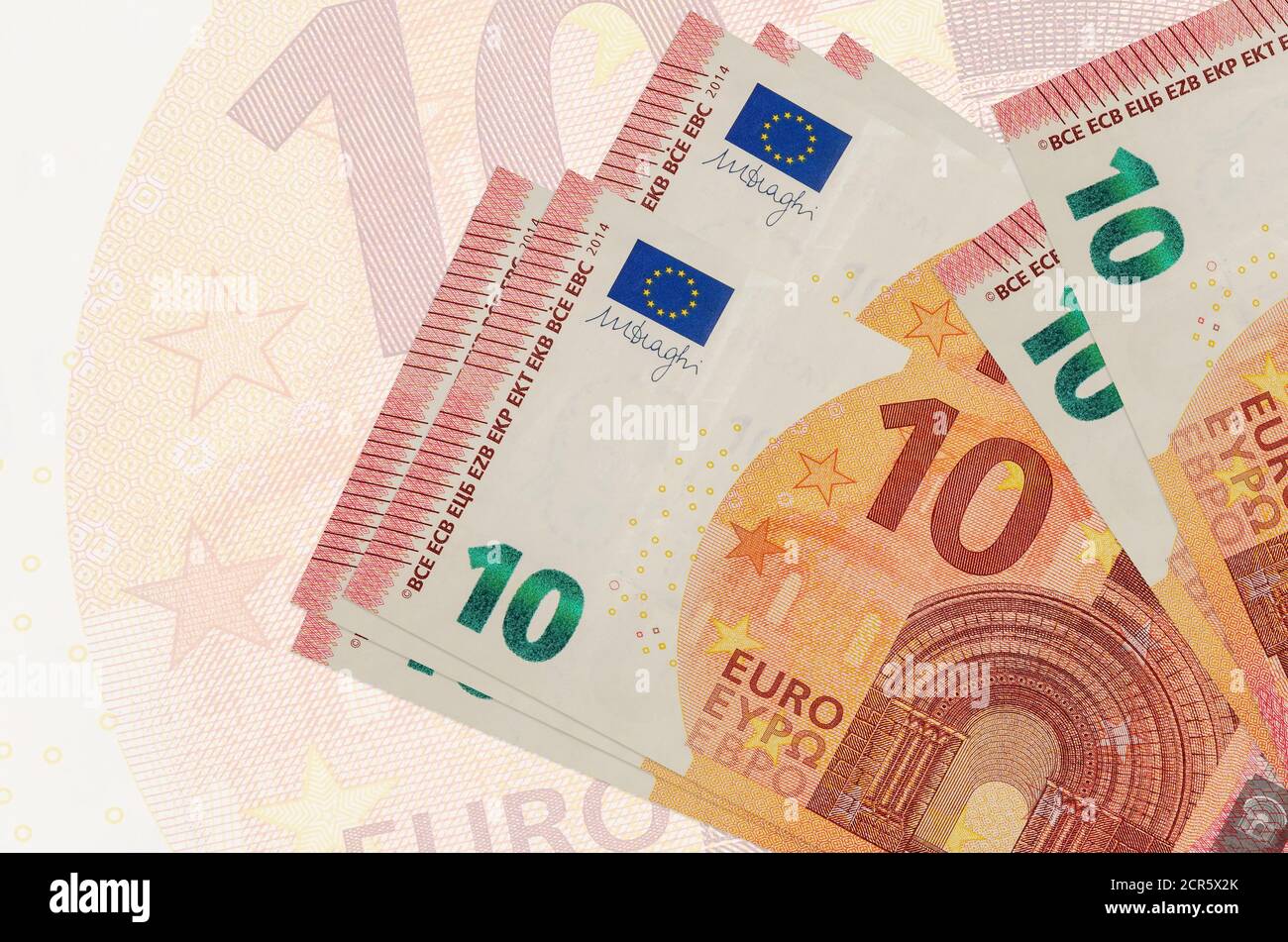 10 euro bills lies in stack on background of big semi-transparent banknote. Abstract ...