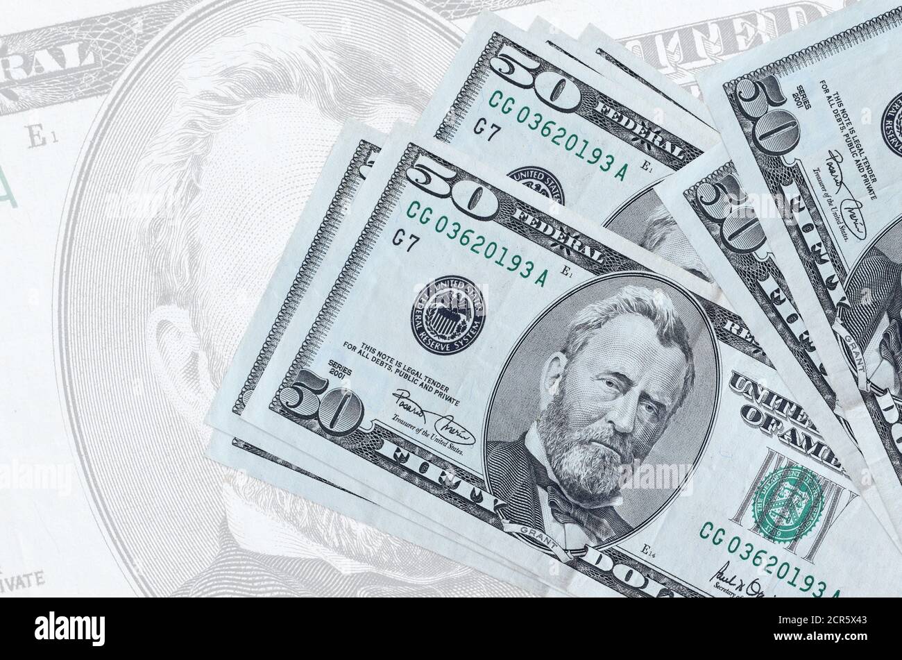 50 US dollars bills lies in stack on background of big semi-transparent ...