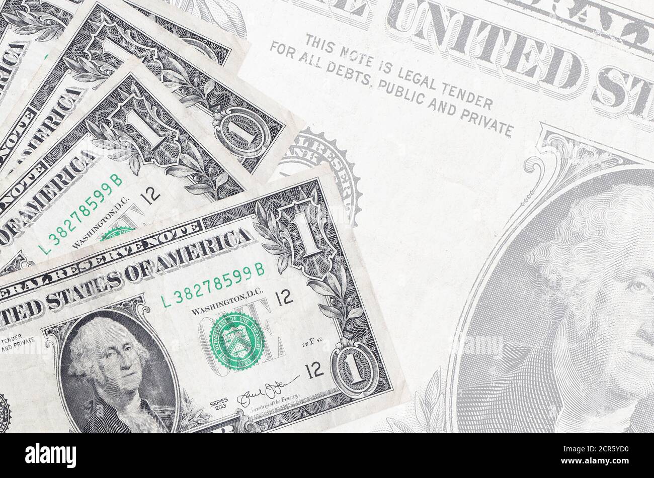 1 US dollar bills lies in stack on background of big semi-transparent ...