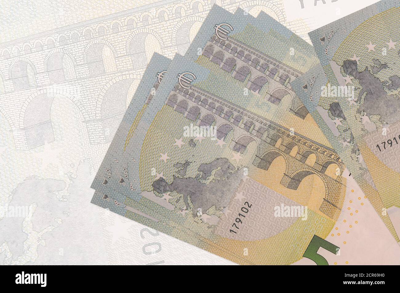 5 euro bills lies in stack on background of big semi-transparent ...