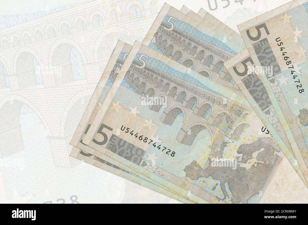 5 euro bills lies in stack on background of big semi-transparent ...