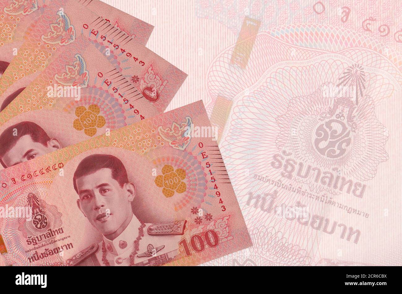 100 Thai baht bills lies in stack on background of big semi-transparent ...