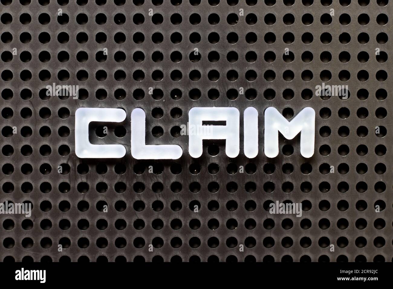White color alphabet with word claim on black pegboard background Stock ...
