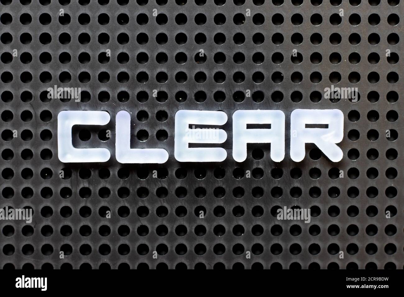 White color alphabet with word clear on black pegboard background Stock ...