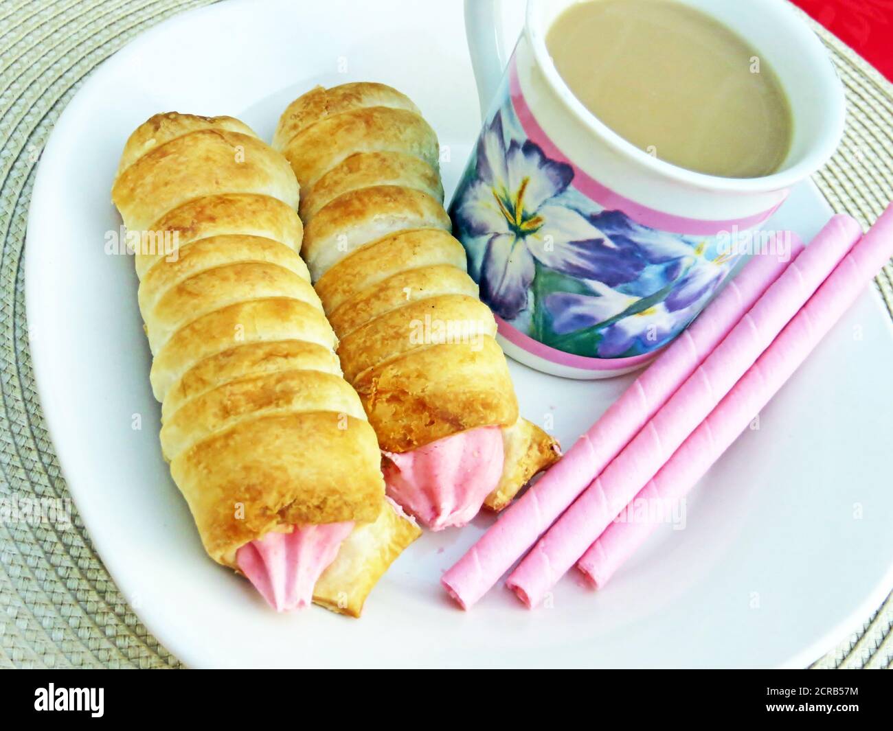 Cup of coffee and strawberry cream filled horns Stock Photo - Alamy