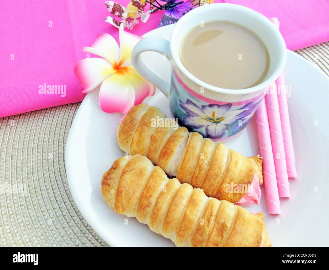 Cup of coffee and strawberry cream filled horns Stock Photo - Alamy