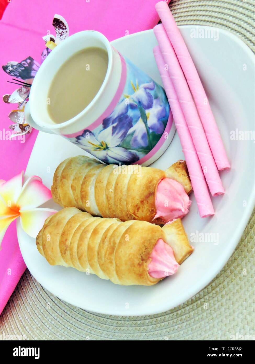Cup of coffee and strawberry cream filled horns Stock Photo - Alamy