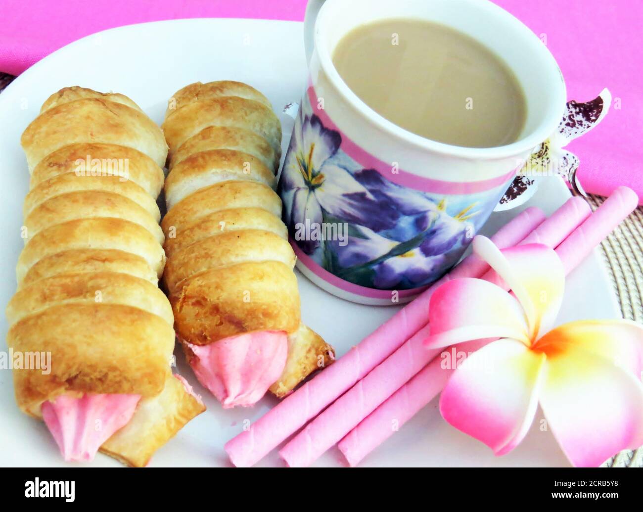 Cup of coffee and strawberry cream filled horns Stock Photo - Alamy