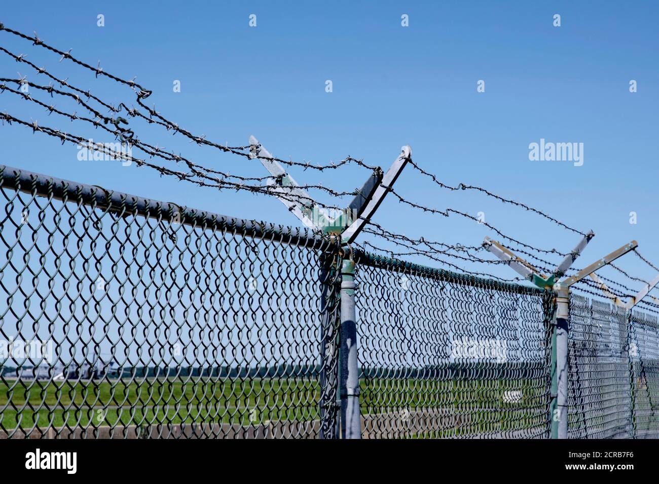 Multiple strands of barbed wire on top of a chain link fence Stock ...
