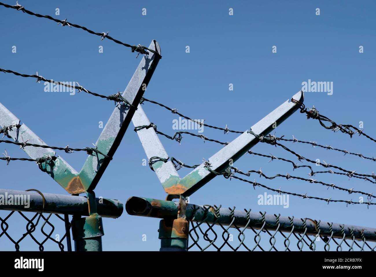 Multiple strands of barbed wire on top of a chain link fence Stock ...