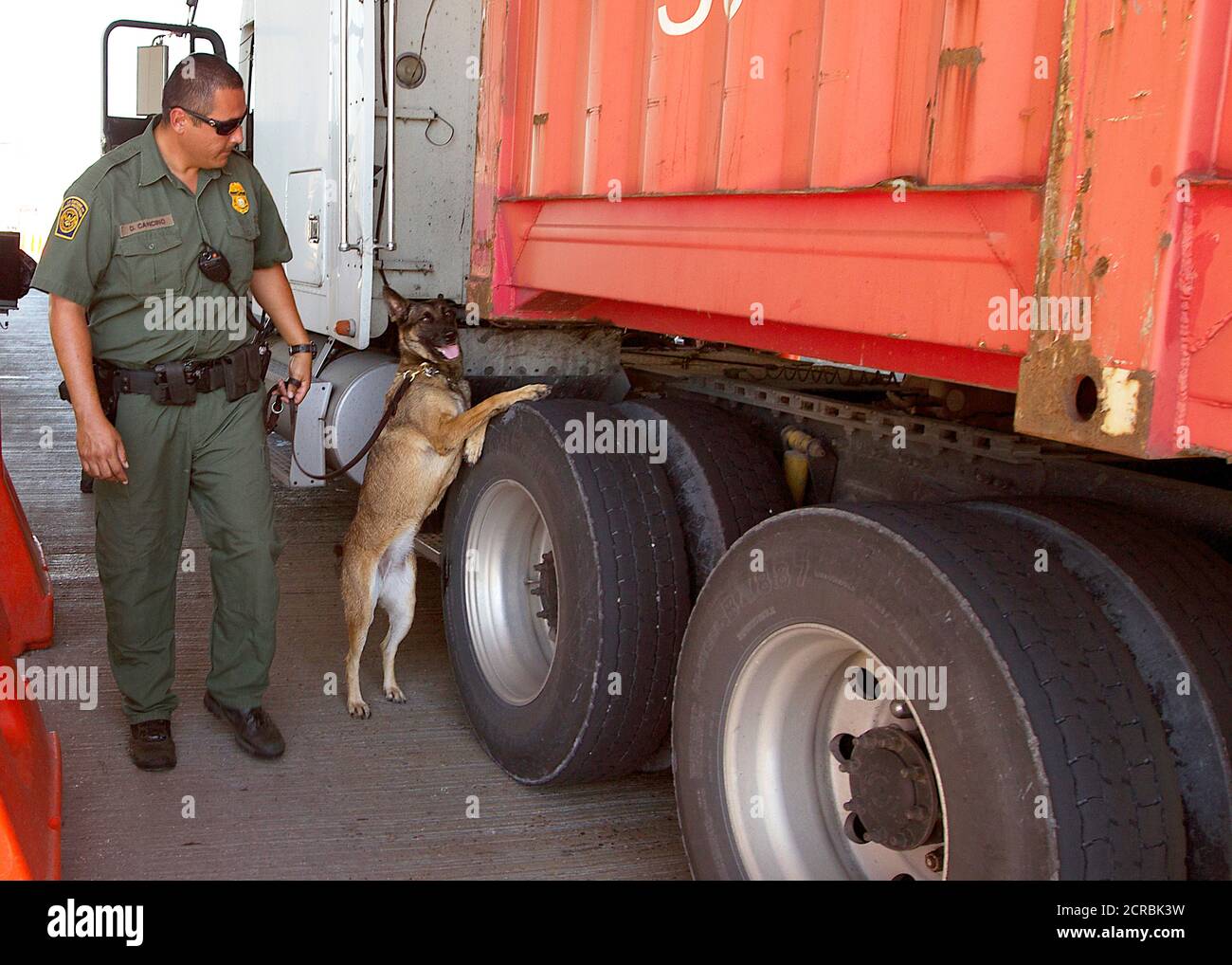 South Texas Border Patrol agent and CBP canine inspect truck at check ...